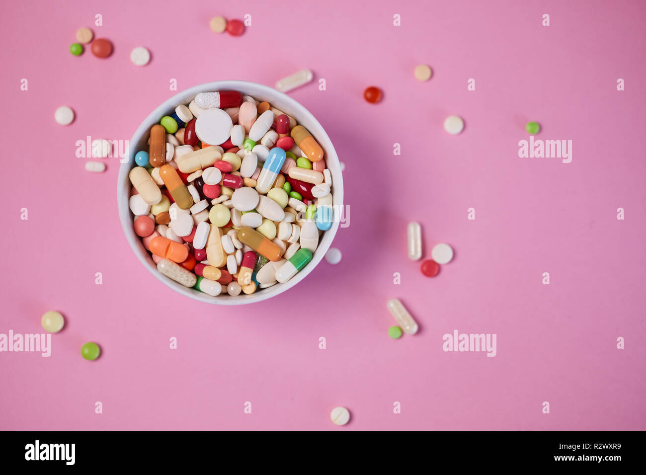Many colorful medicines in a shell on a pink background Stock Photo - Alamy