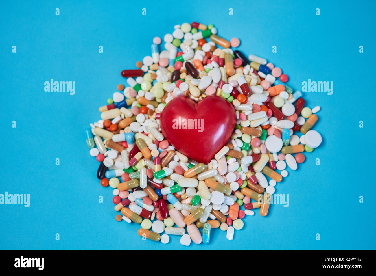 Red heart in a pile of colorful medicines as a cardiology concept Stock ...