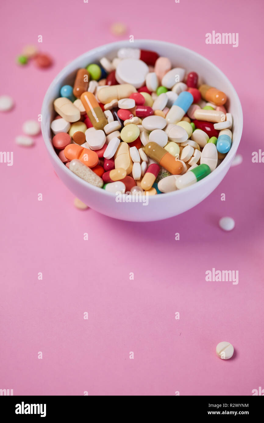 Bowl full of colorful medicine medicines on a pink background Stock ...