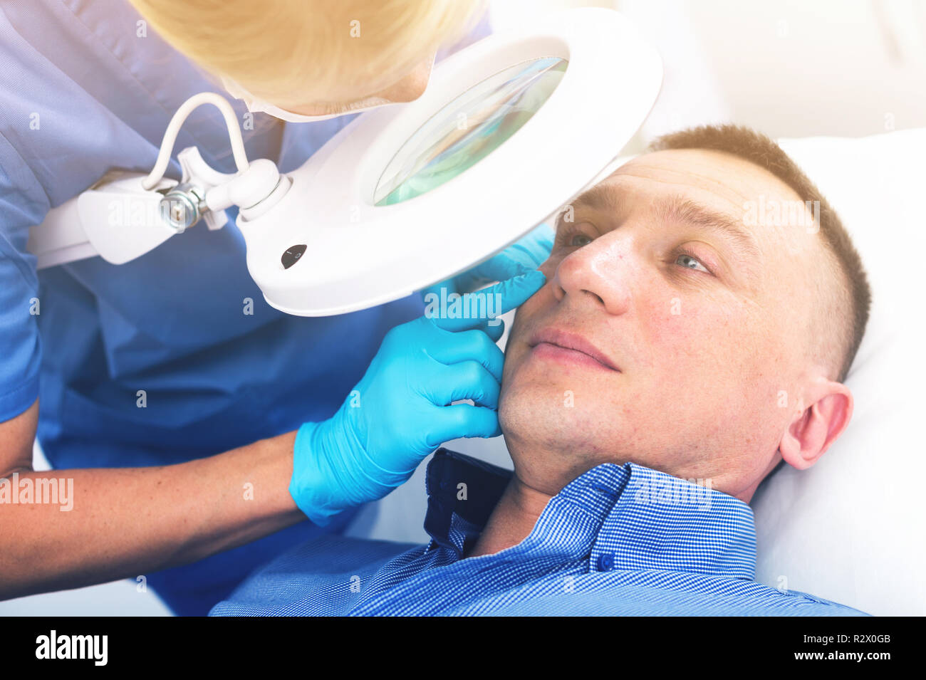 Female doctor is doing cleaning skin procedure to client in cabinet ...