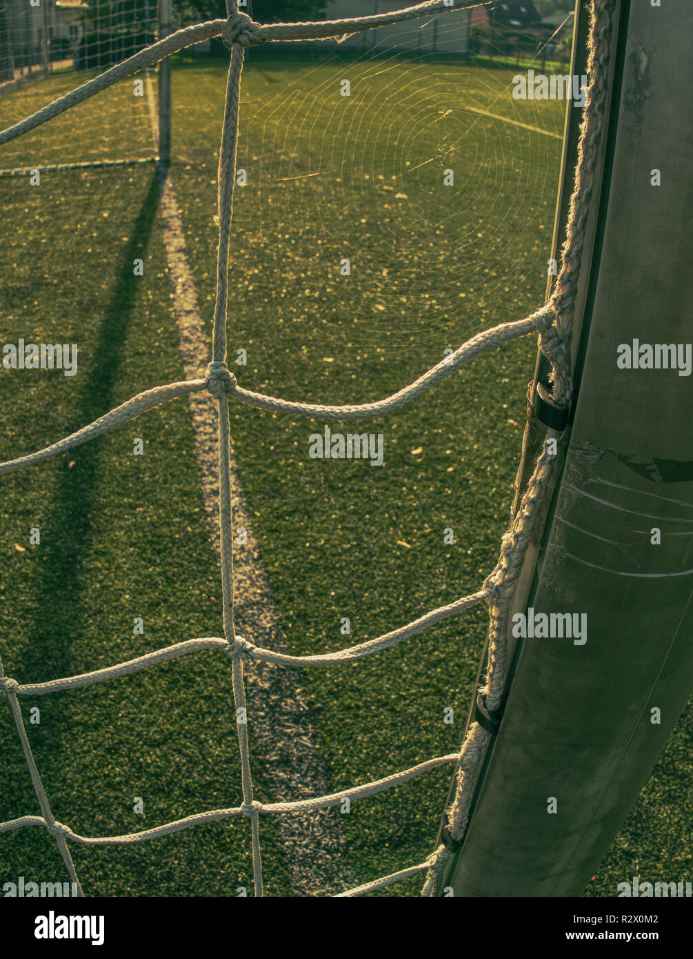 The soccer green field viewed through white square gate net. Football ...