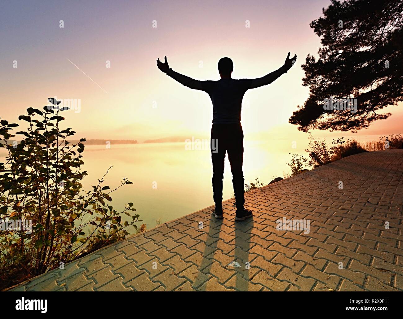 Mature man stretches muscles while resting after jogging. Happy sports man feeling refreshed ...