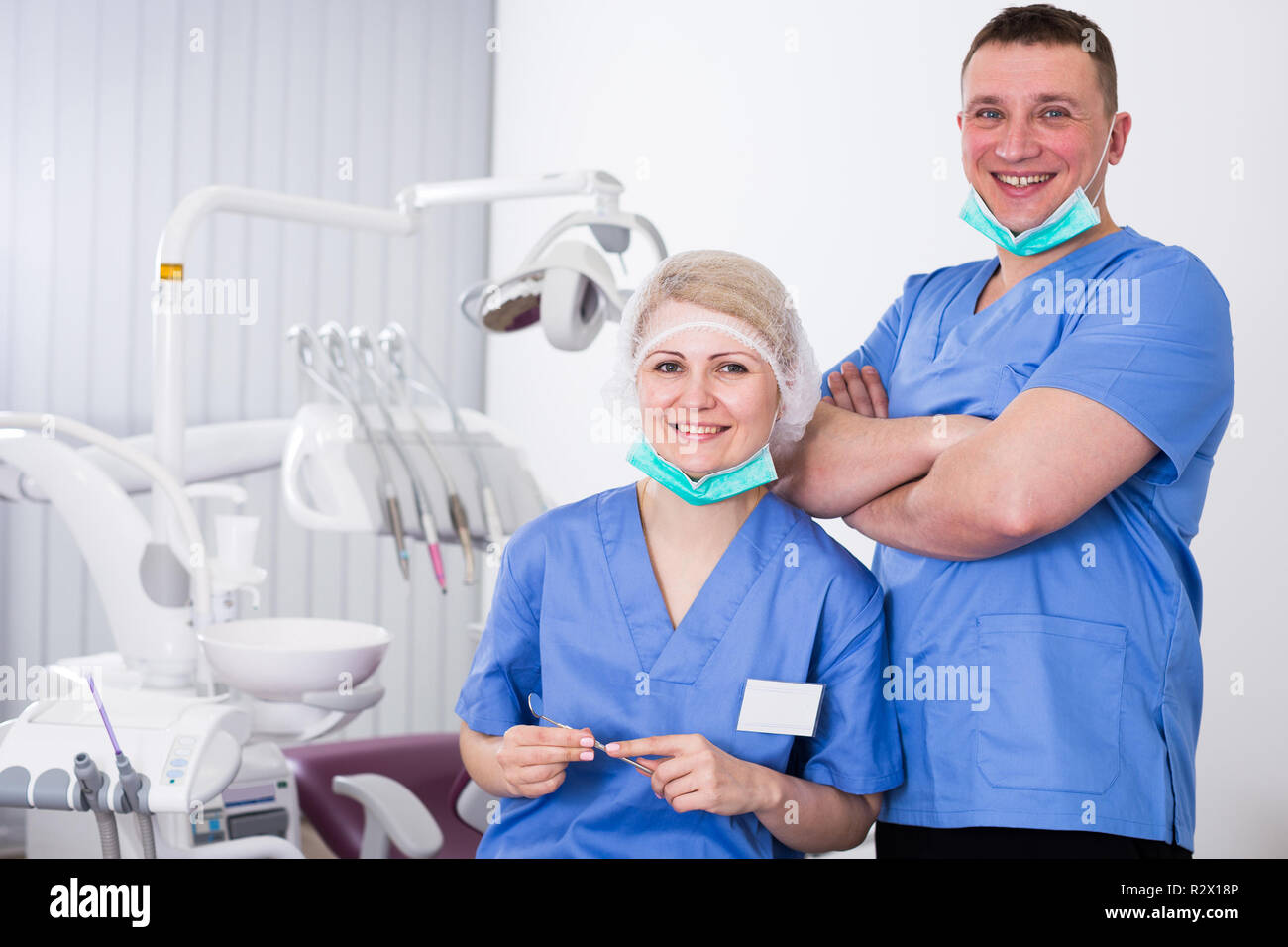 Two successful smiling professional dentists posing at modern dental ...