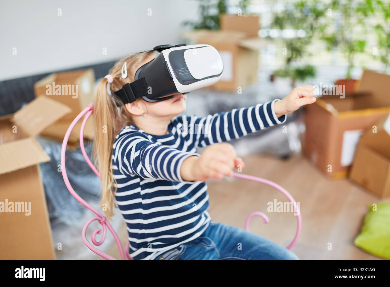 Girl with virtual reality glasses goes through a virtual house as a ...