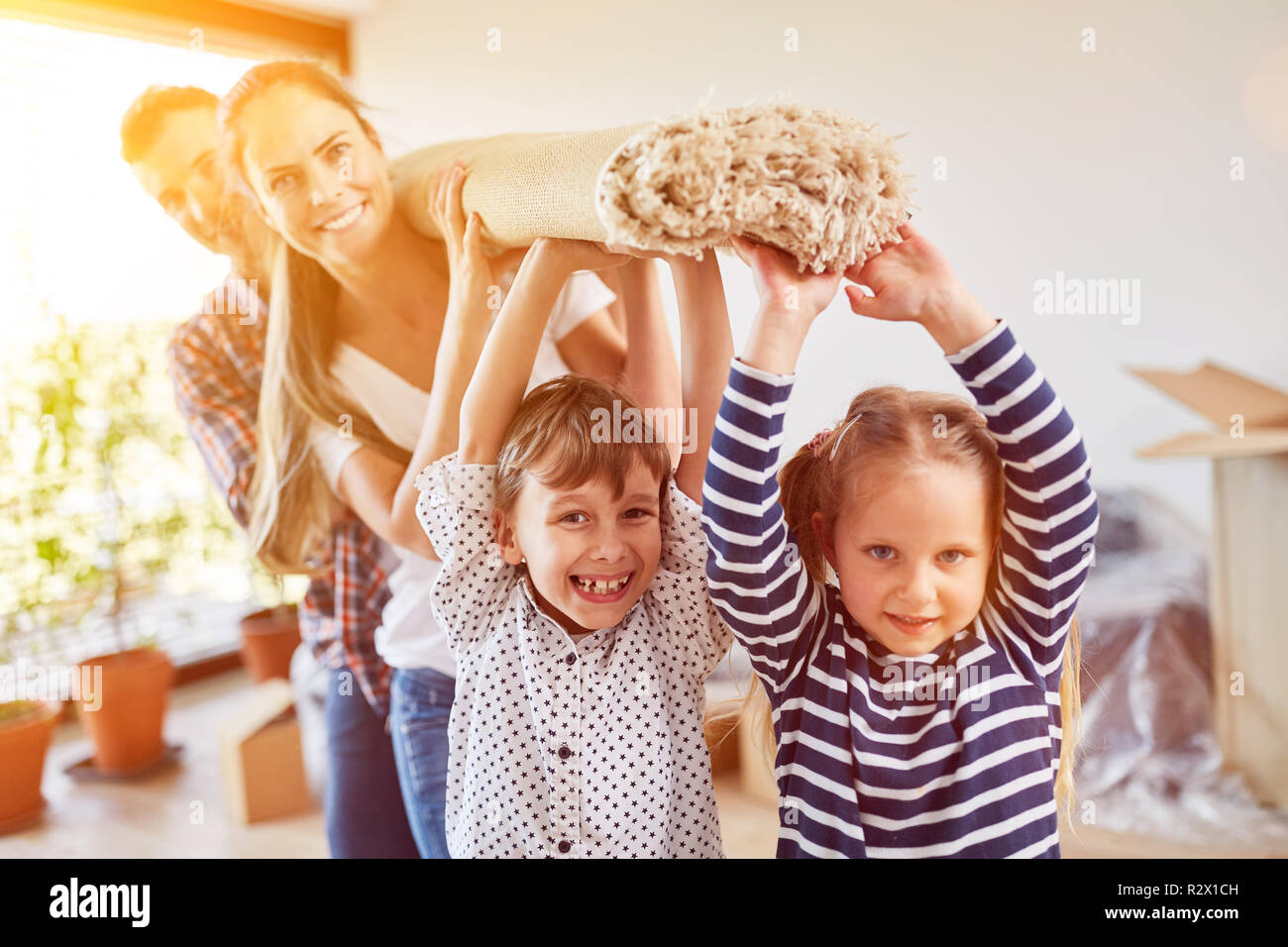 Children help family wear carpet in the new home Stock Photo - Alamy