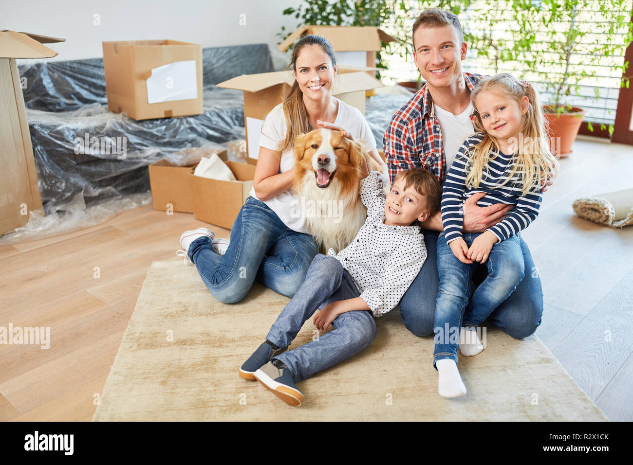 Happy family with two kids and dog in new home as a home Stock Photo ...