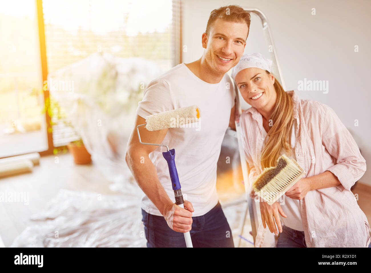 Couple painting and wallpapering while renovating their new home Stock ... Couple painting and wallpapering while renovating their new home Stock ...