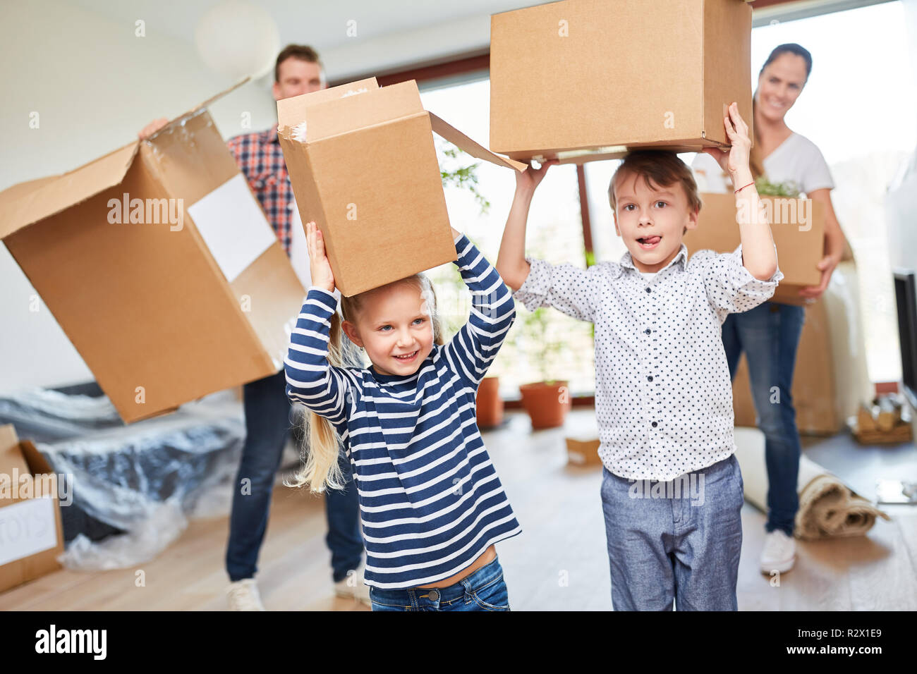 Family and children together carry moving boxes when moving to the new ...