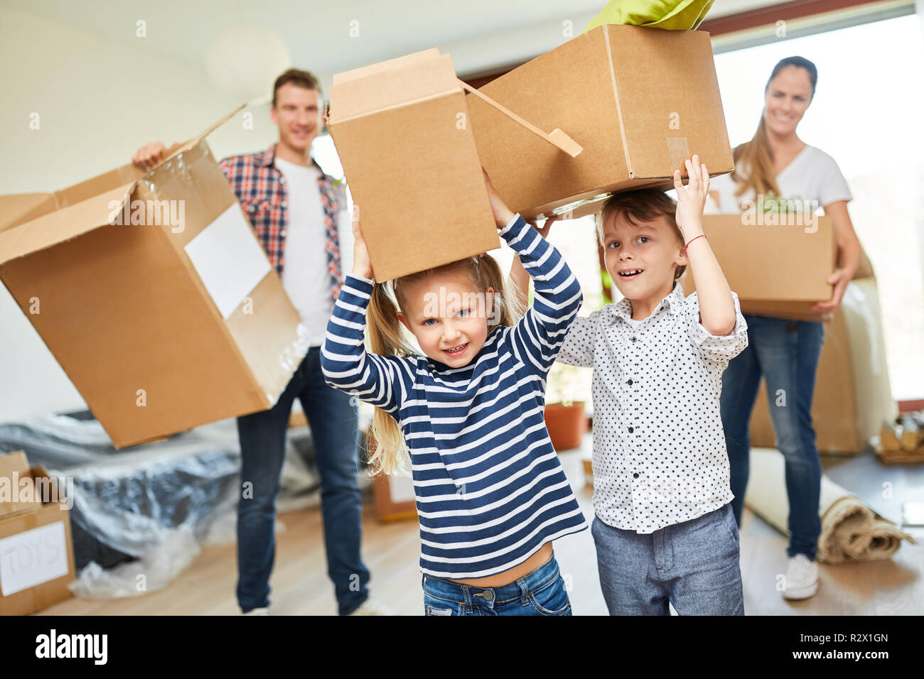 Children help parents with the move and carry moving boxes to the new ...