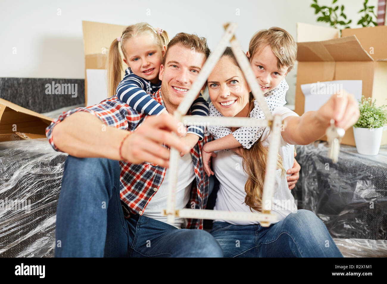 Family and children with folding rule in the form of house as a symbol ...