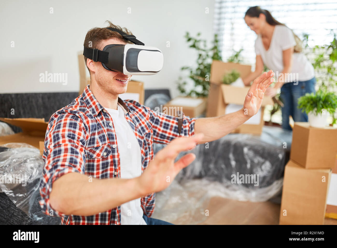 Couple in room planning with virtual reality glasses after moving in ...