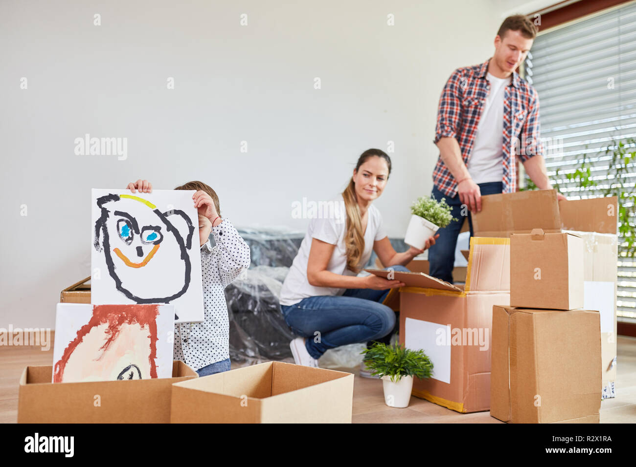 Parents and children together pack moving boxes from the move to the ...