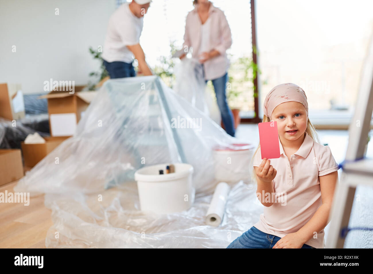 Girl helps with painting, showing wall paint in pink for room design ...