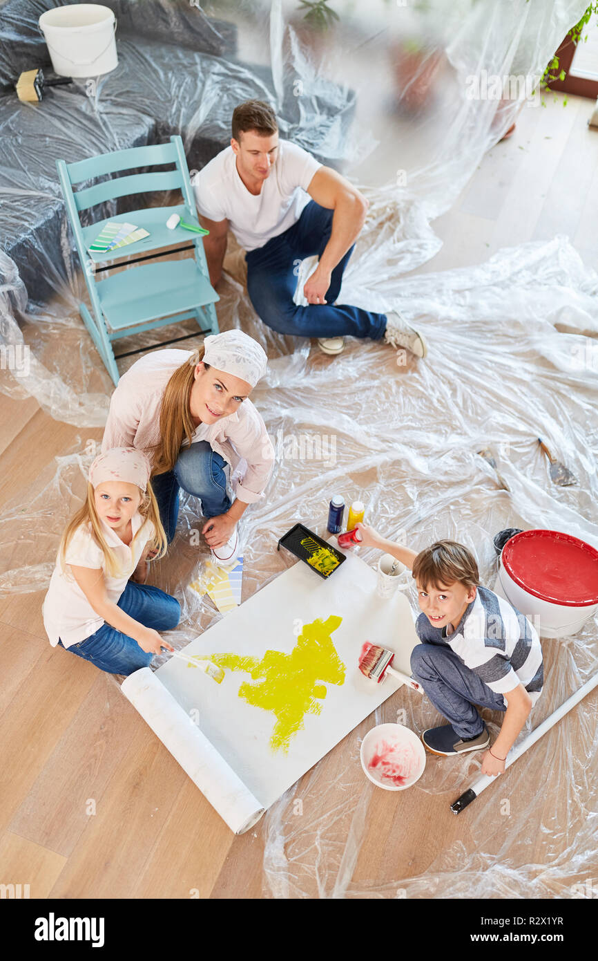 Family and children paint a wallpaper while renovating in the new home ...