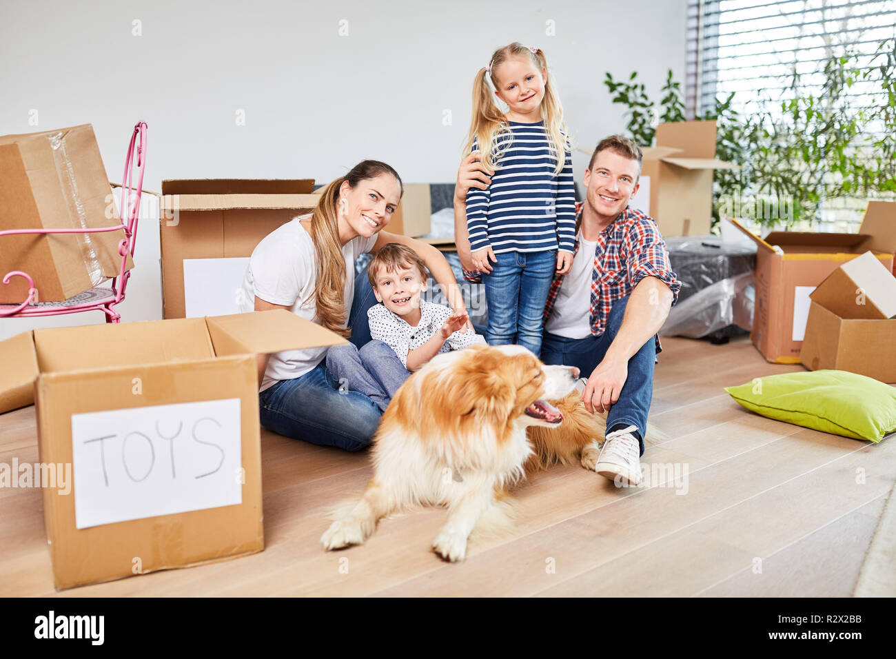 Happy family with children and dog moving with many moving boxes Stock ...