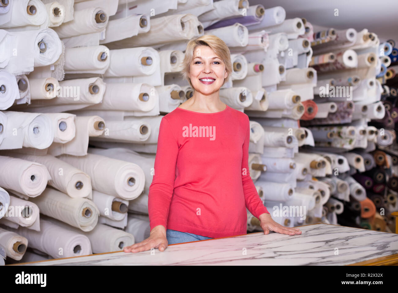 smiling american female shop assistant demonstrating assortment at ...
