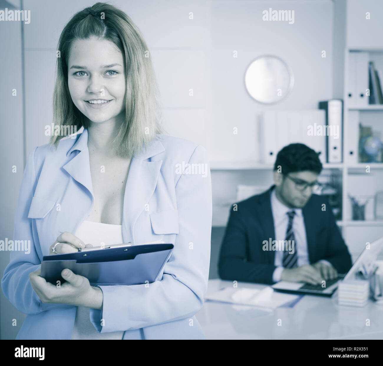 Attractive secretary helping boss and writing instructions at workplace ...