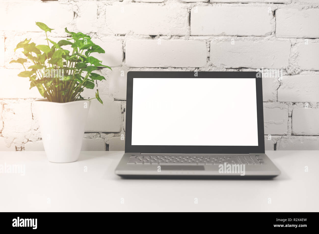 laptop with blank screen in front of white brick wall Stock Photo - Alamy