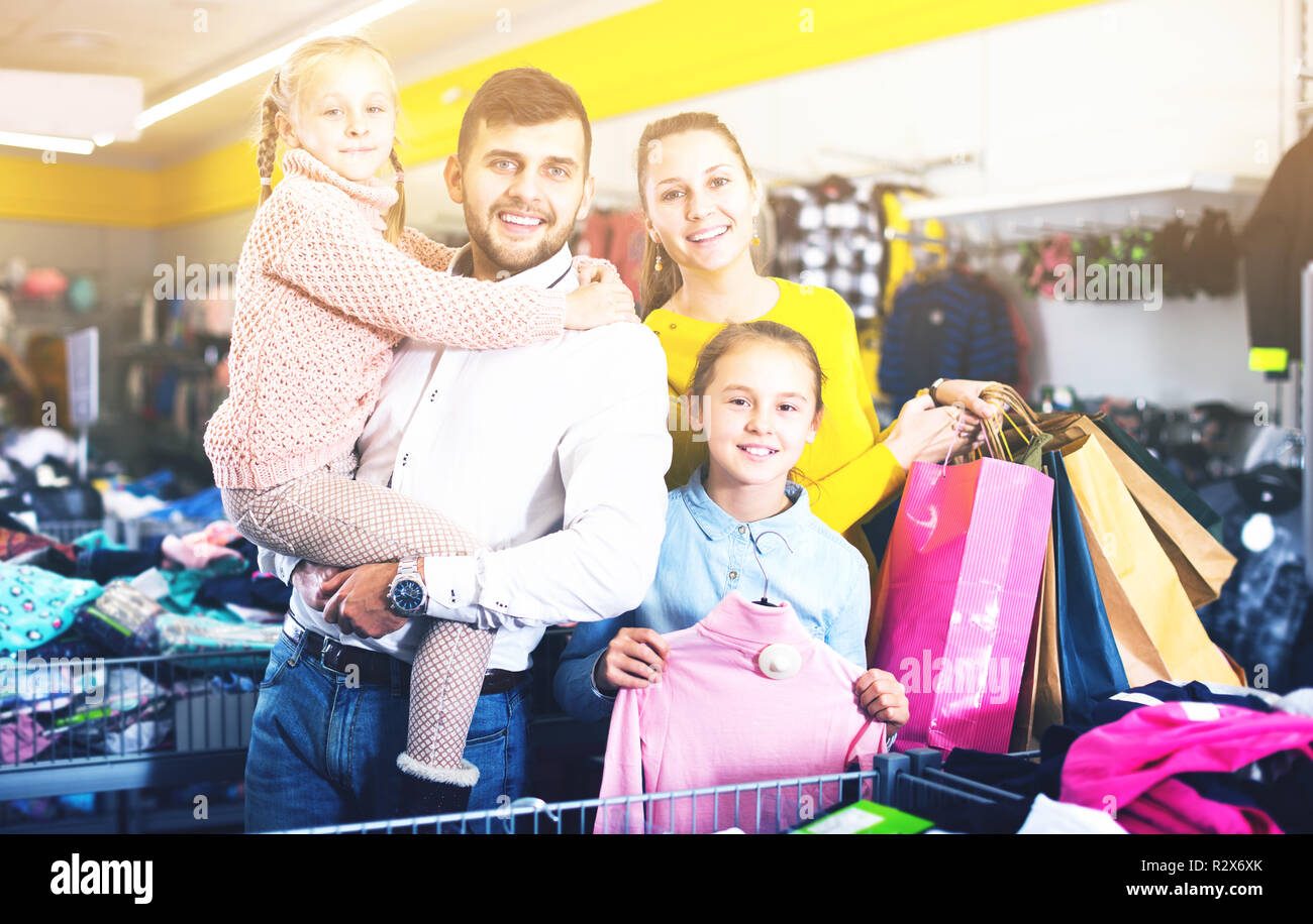 Young cheerful family with two daughters after shopping in shop Stock ...