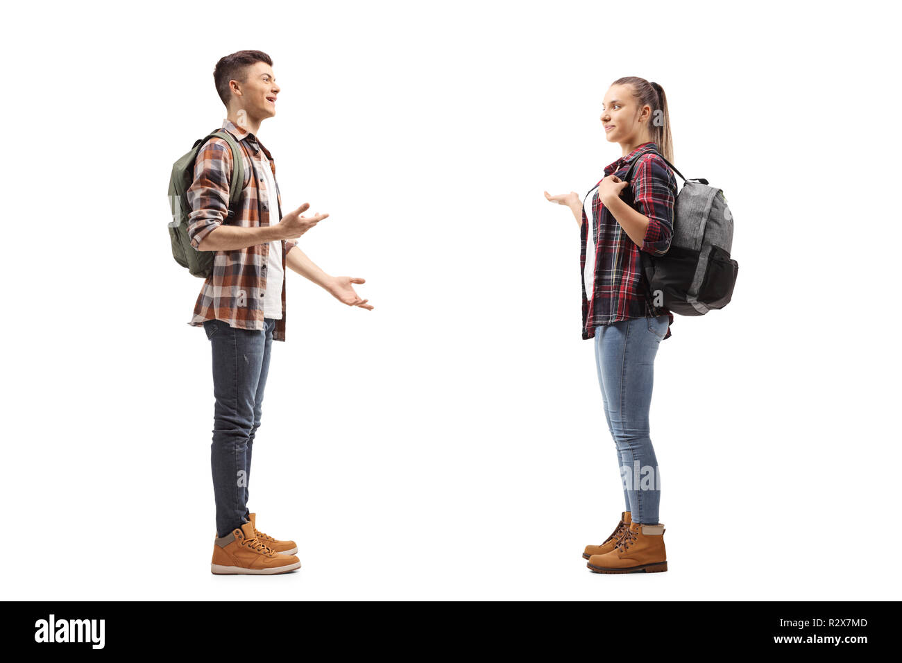 Full length profile shot of teenage students talking with each other ...