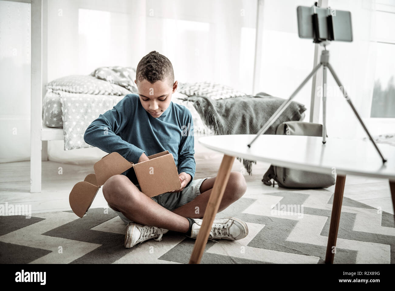 Serious cute boy looking into the box Stock Photo - Alamy