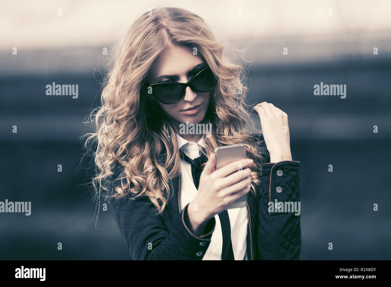 Blond business woman using cell phone in city street Stylish fashion ...