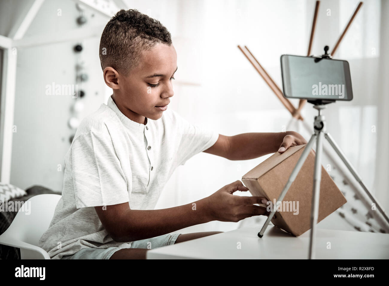 Nice cute boy opening a cardboard box Stock Photo - Alamy