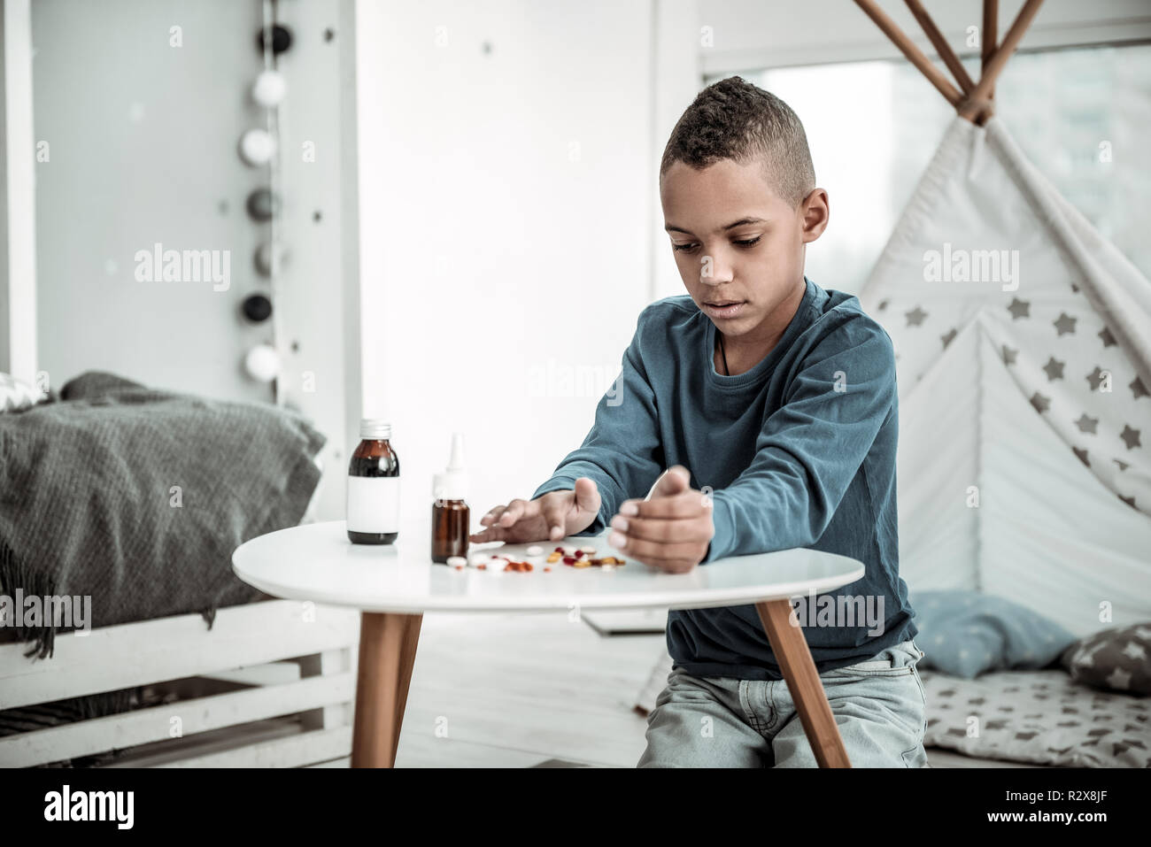 Sad nice boy sitting in his room Stock Photo - Alamy