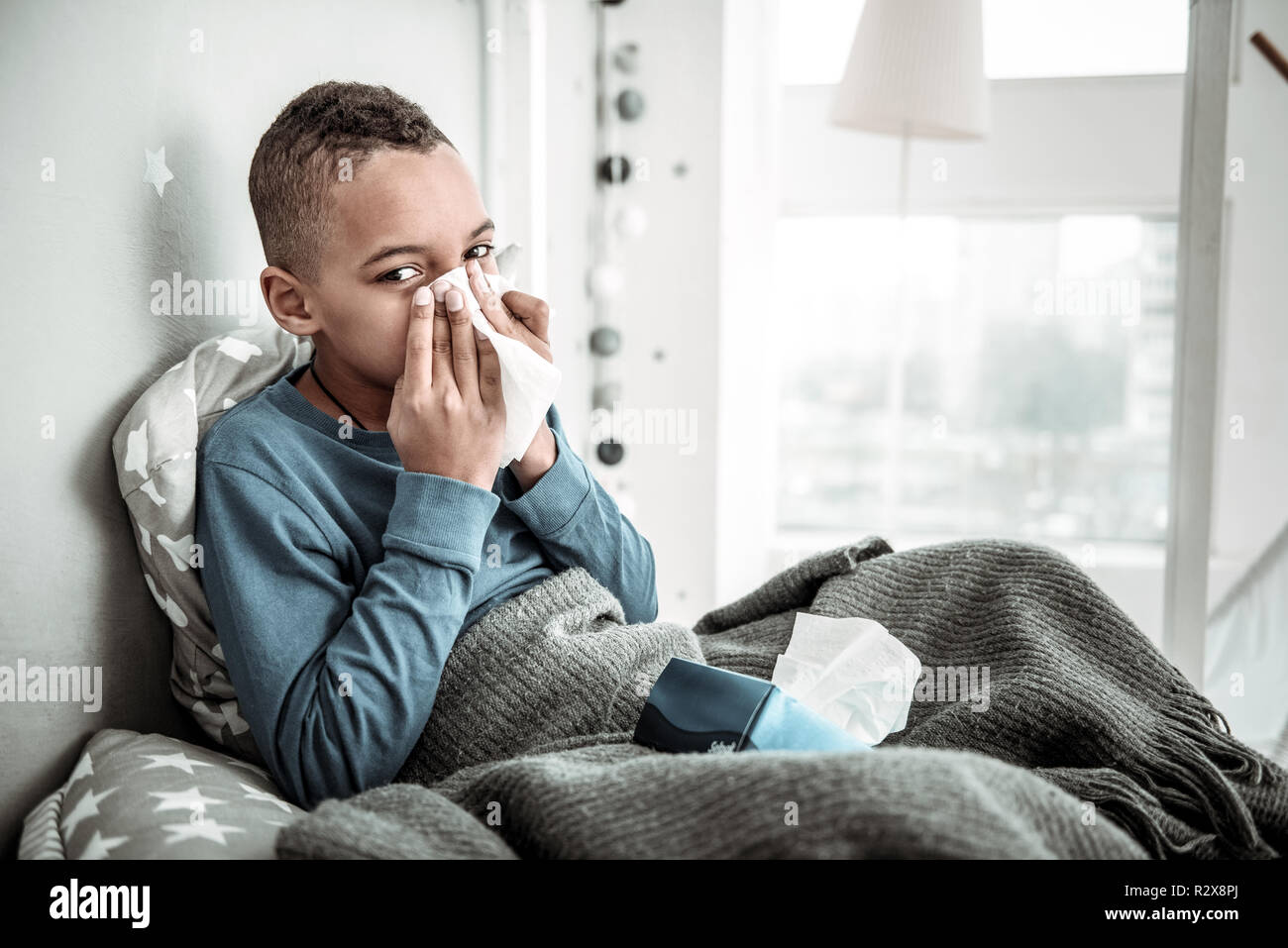 Pleasant cute boy holding a paper tissue Stock Photo - Alamy