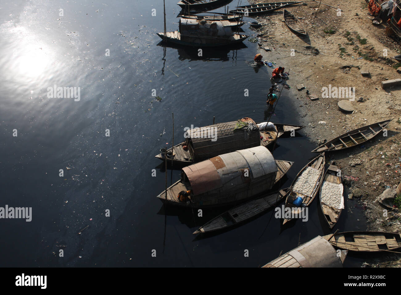 A row of narrow boats belonging to gypsies moored on the Turag River in ...