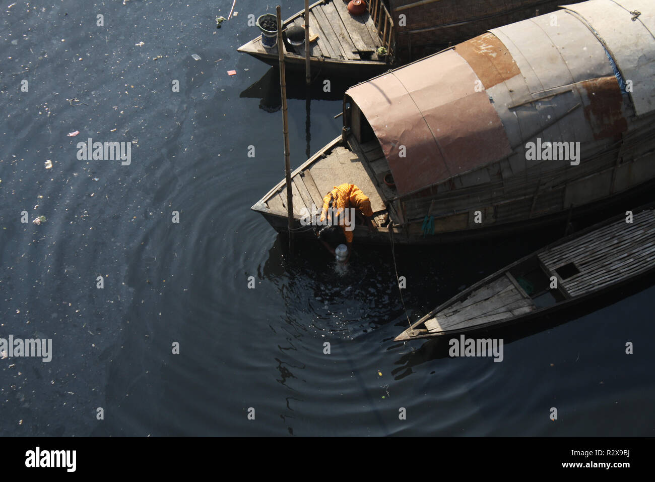 A row of narrow boats belonging to gypsies moored on the Turag River in ...