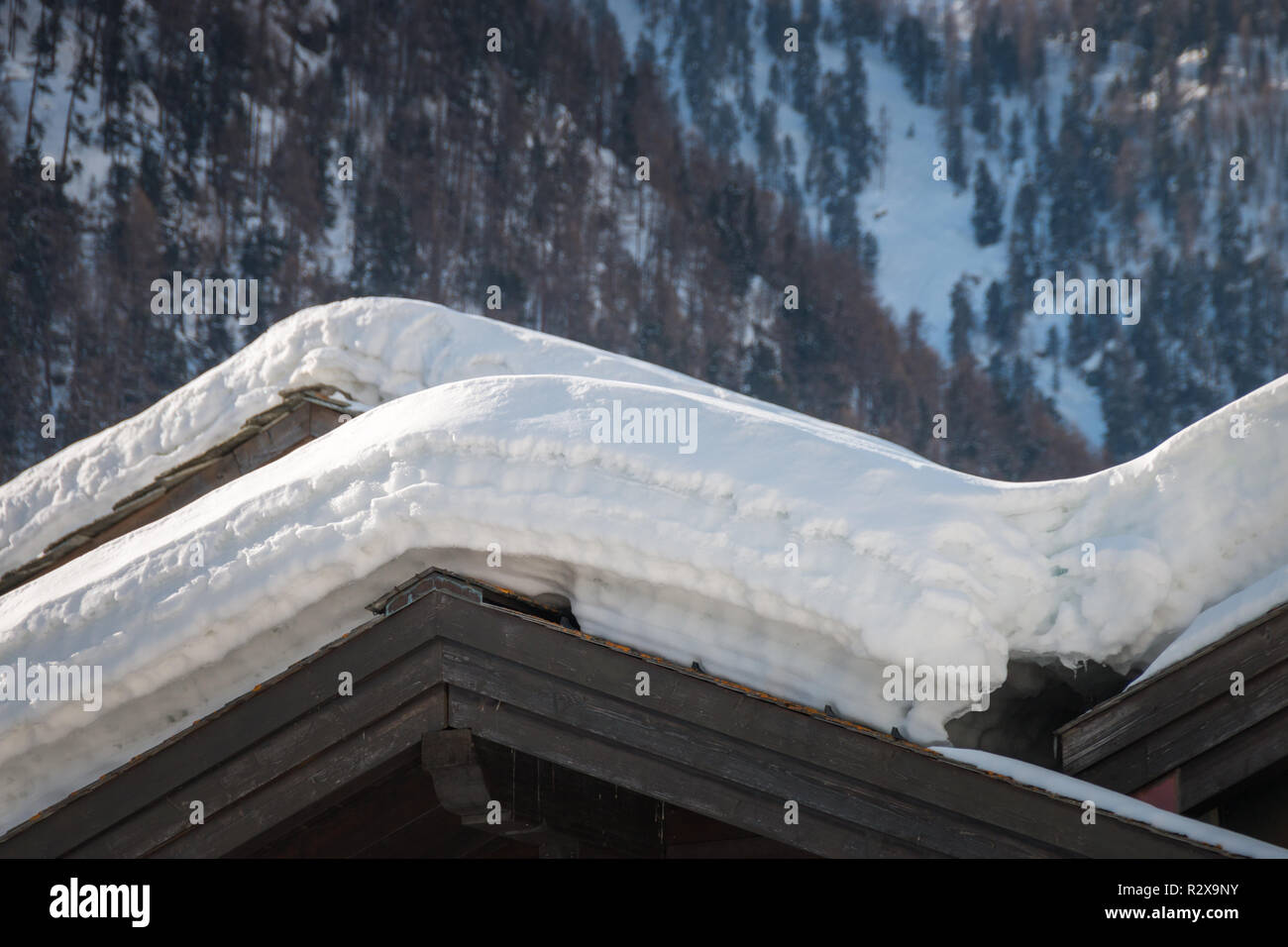 Lots of snow in layers on the rooftop of residential houses on a sunny ...