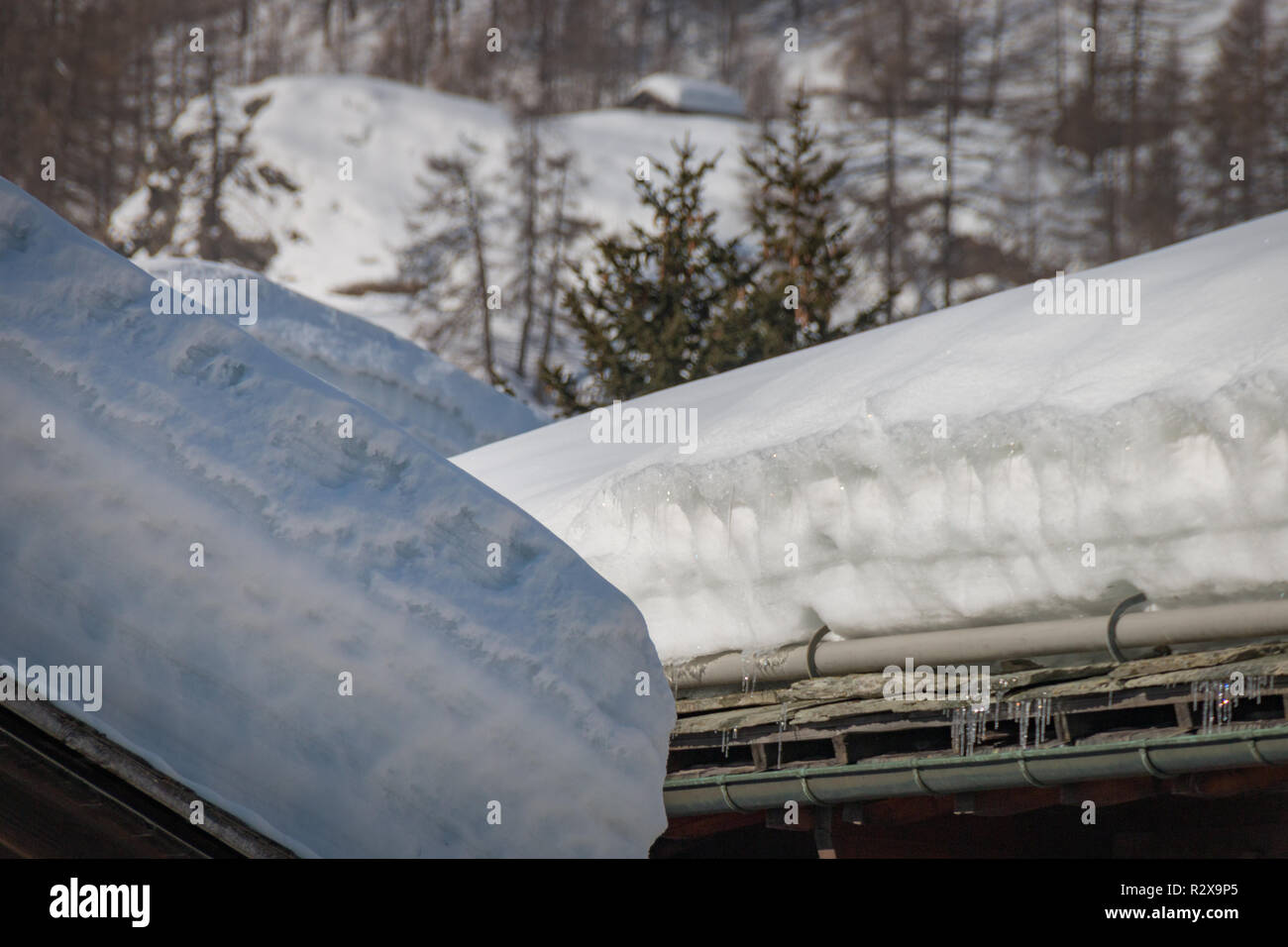 Lots of snow in layers on the rooftop of residential houses on a sunny ...