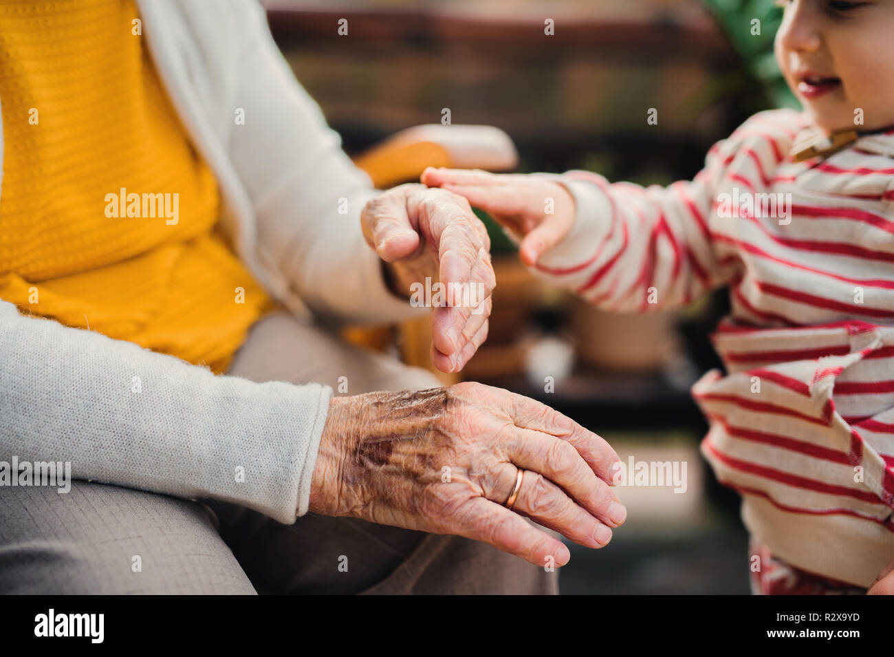 A midsection of ederly woman with a toddler great-grandchild outdoors ...