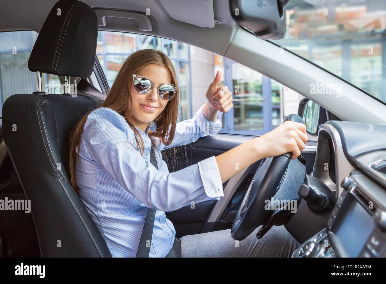a young girl driving a car in the town Stock Photo - Alamy