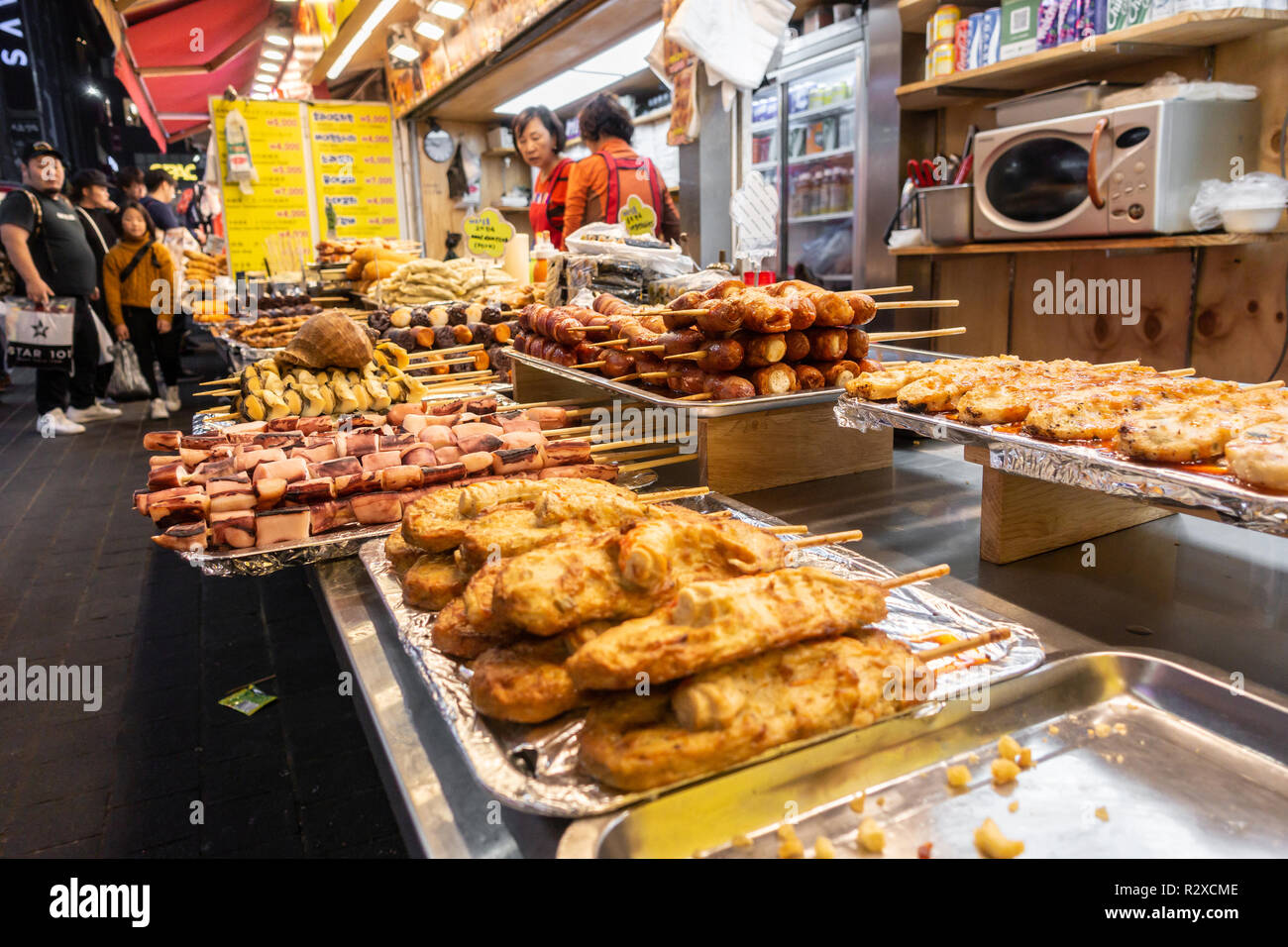 A stall selling different types of street food on wooden skewers in ...