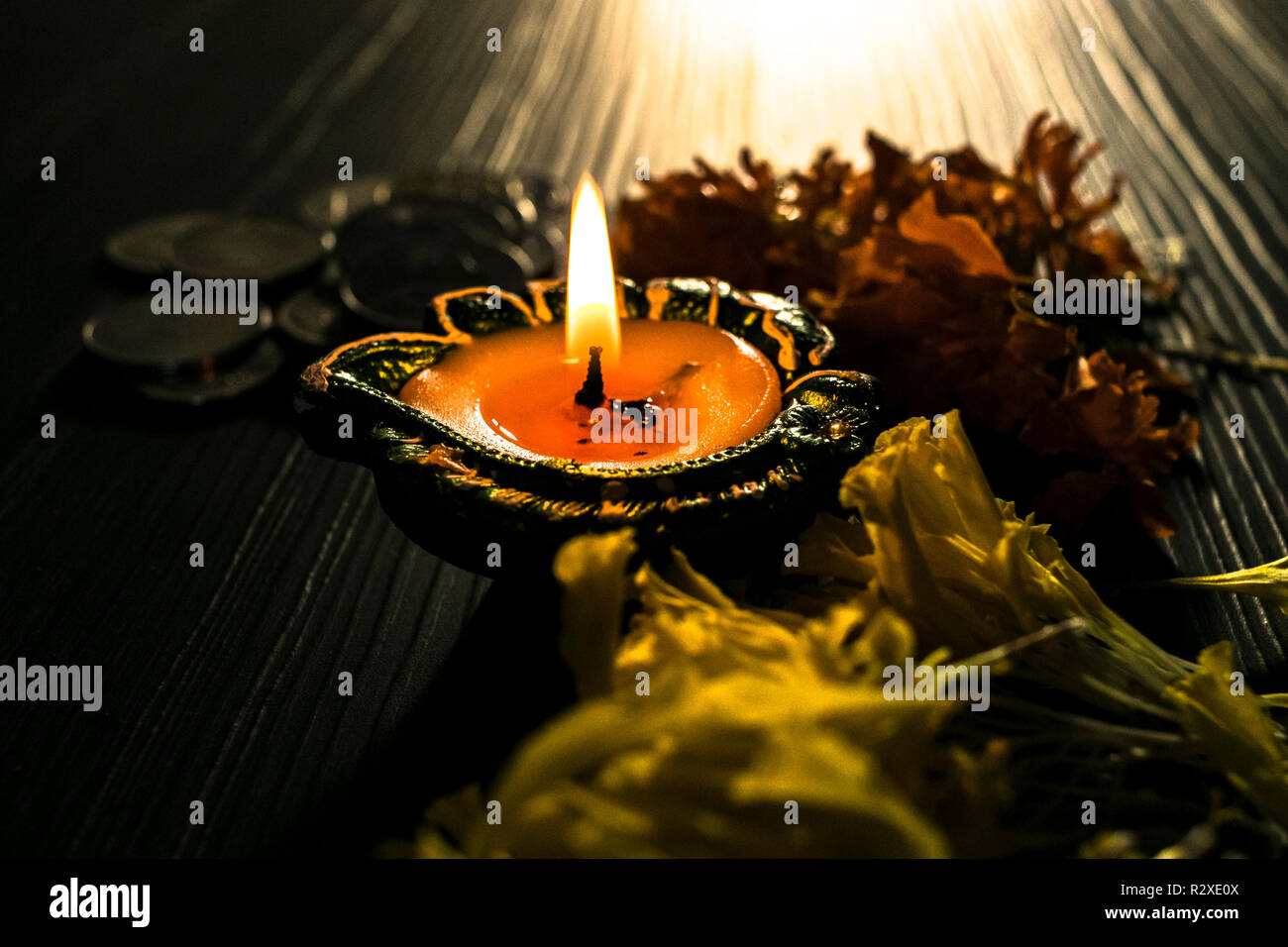 A front view of lit diya with flowers to celebrate diwali and dhanteras ...