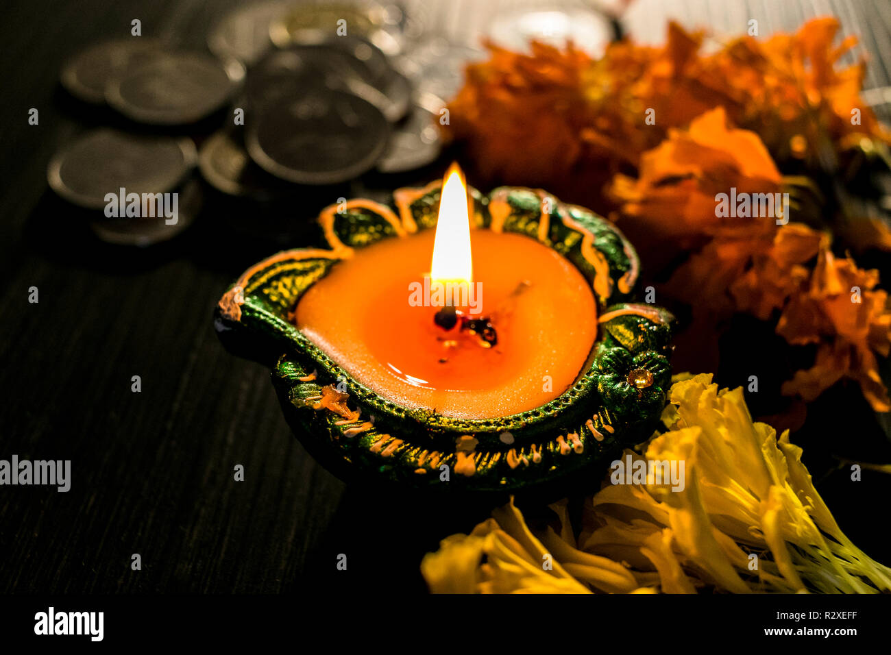 A front view of lit diya with flowers to celebrate diwali and dhanteras ...