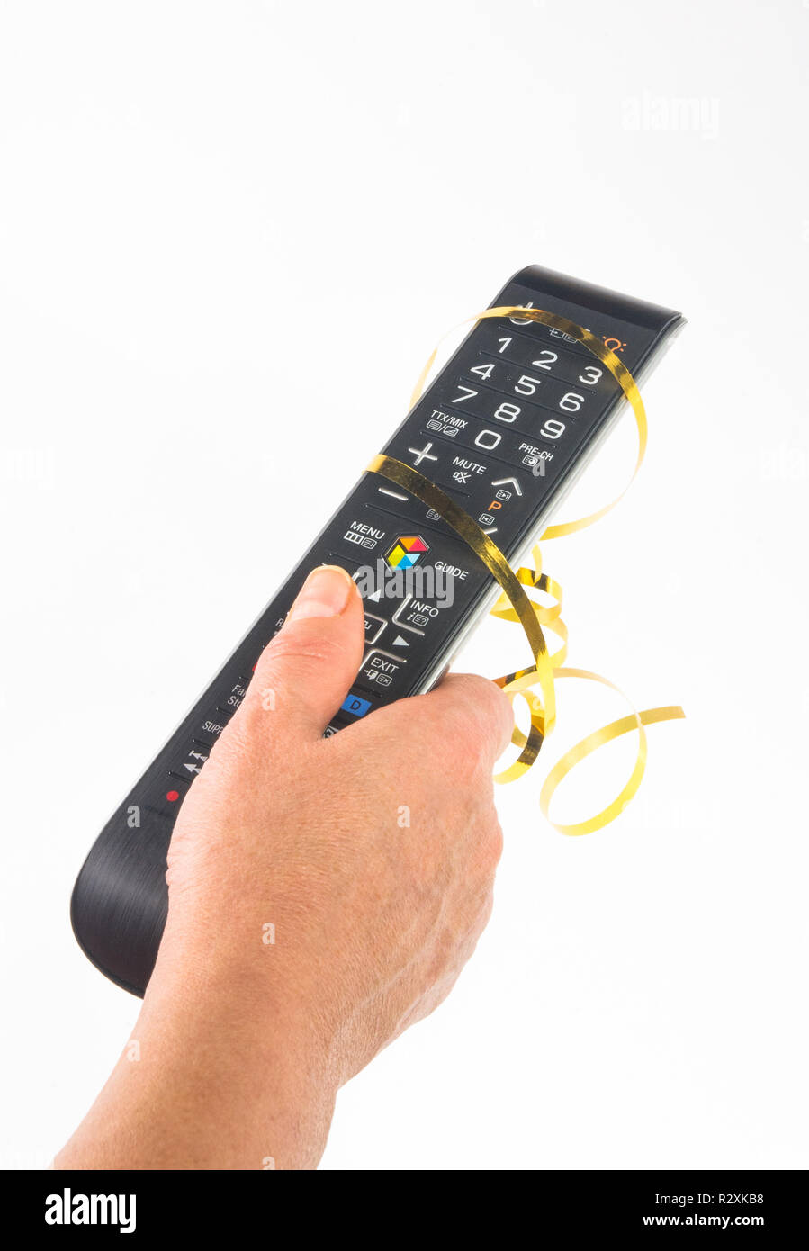 hand holding a remote control in a festive gold ribbon on white ...