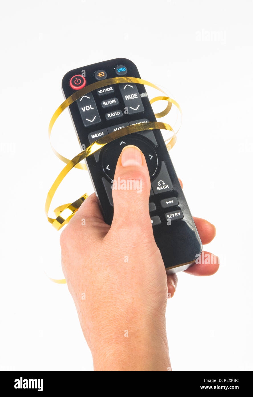 hand holding a remote control in a festive gold ribbon on white ...