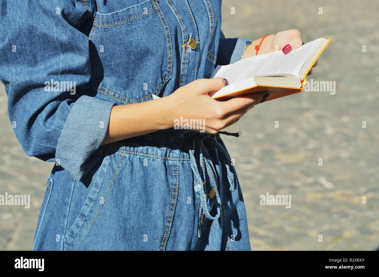 Happy cute young woman student holding books and walking outdoors Stock ...