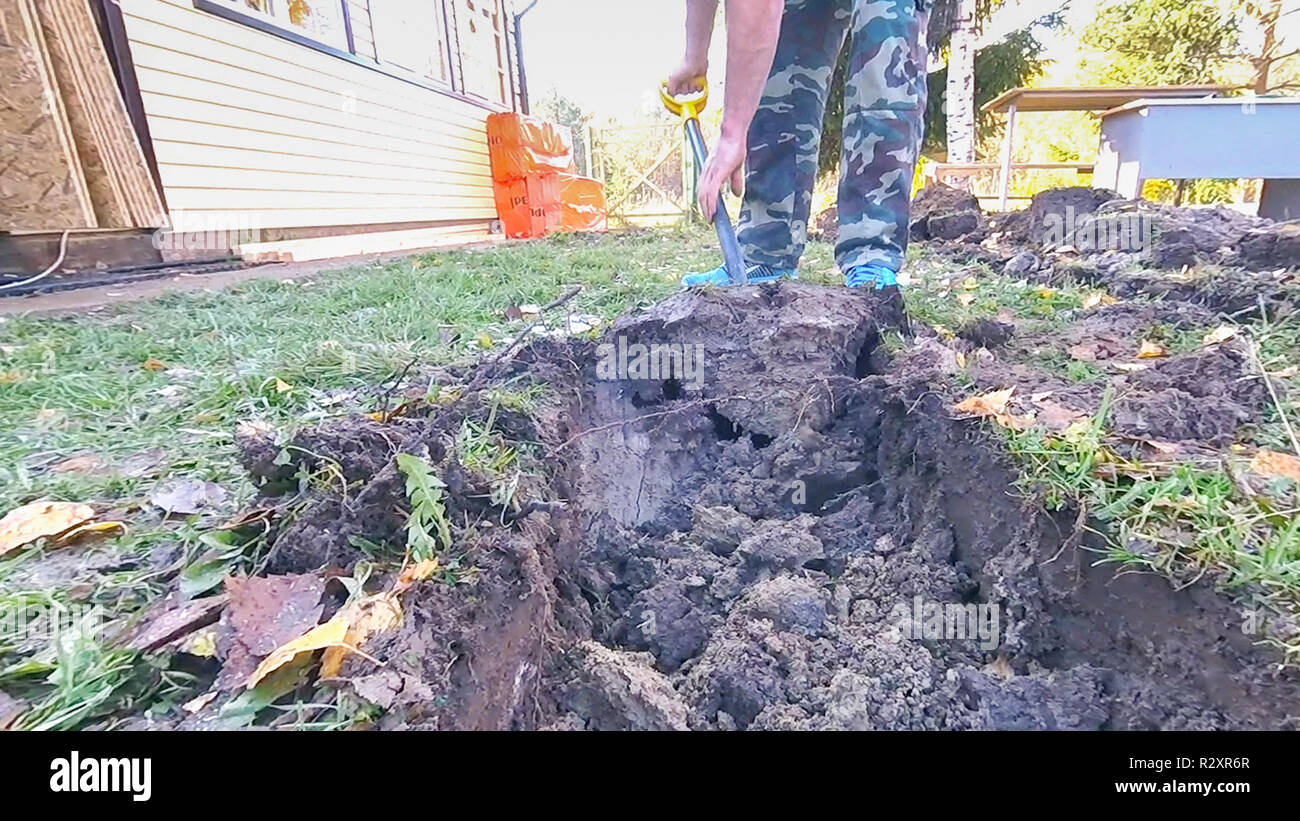 Digging clay in the ground with a shovel in the fall Stock Photo - Alamy