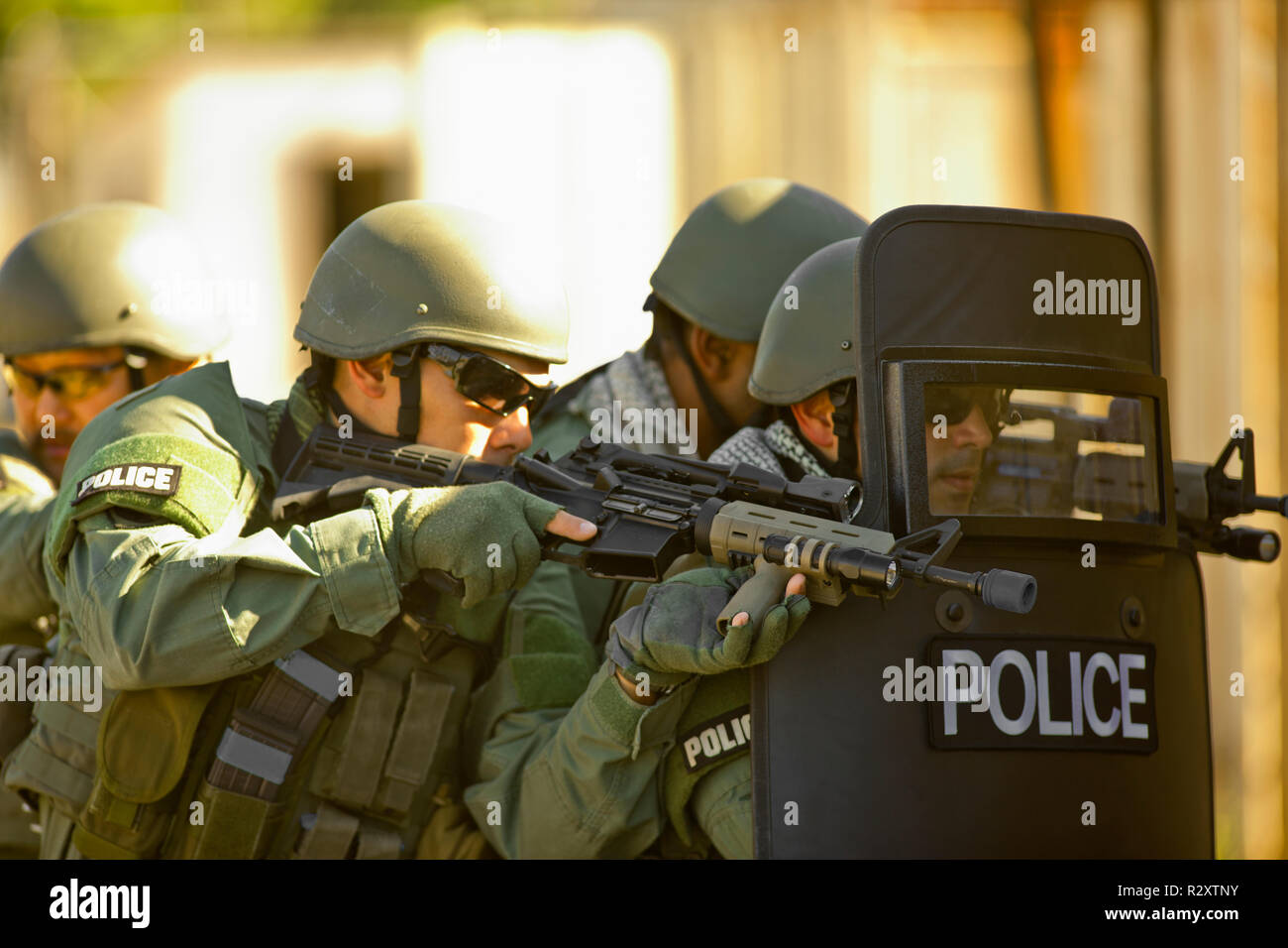 Four police officers holding weapons and protection about to enter a ...