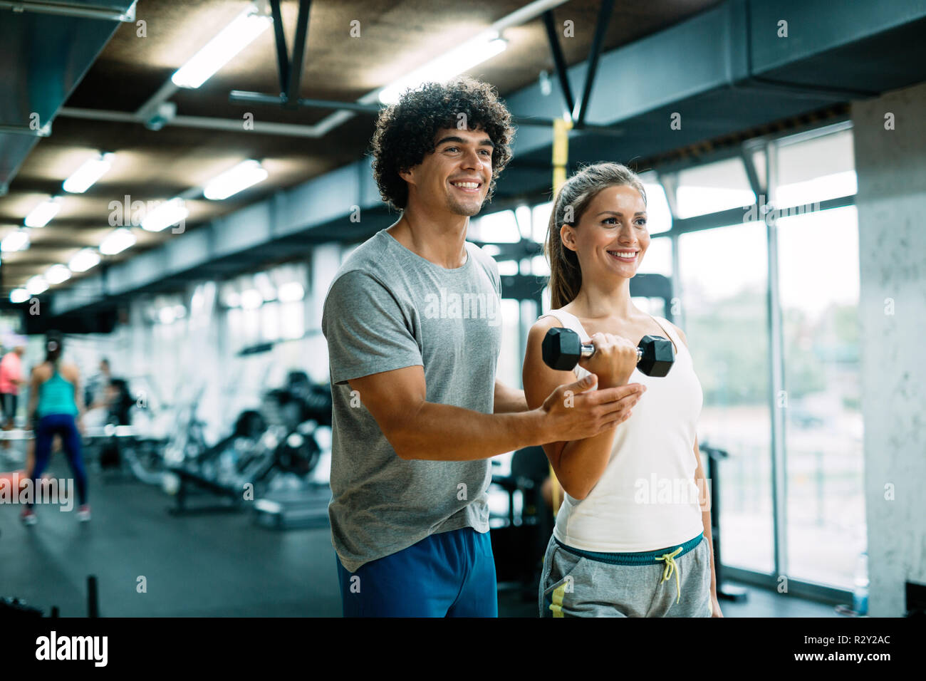 Personal trainer helping young woman reach goals Stock Photo - Alamy