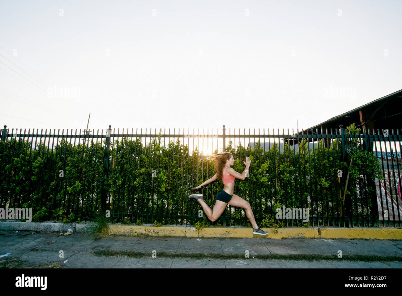 Female athlete running along street at dusk Stock Photo - Alamy