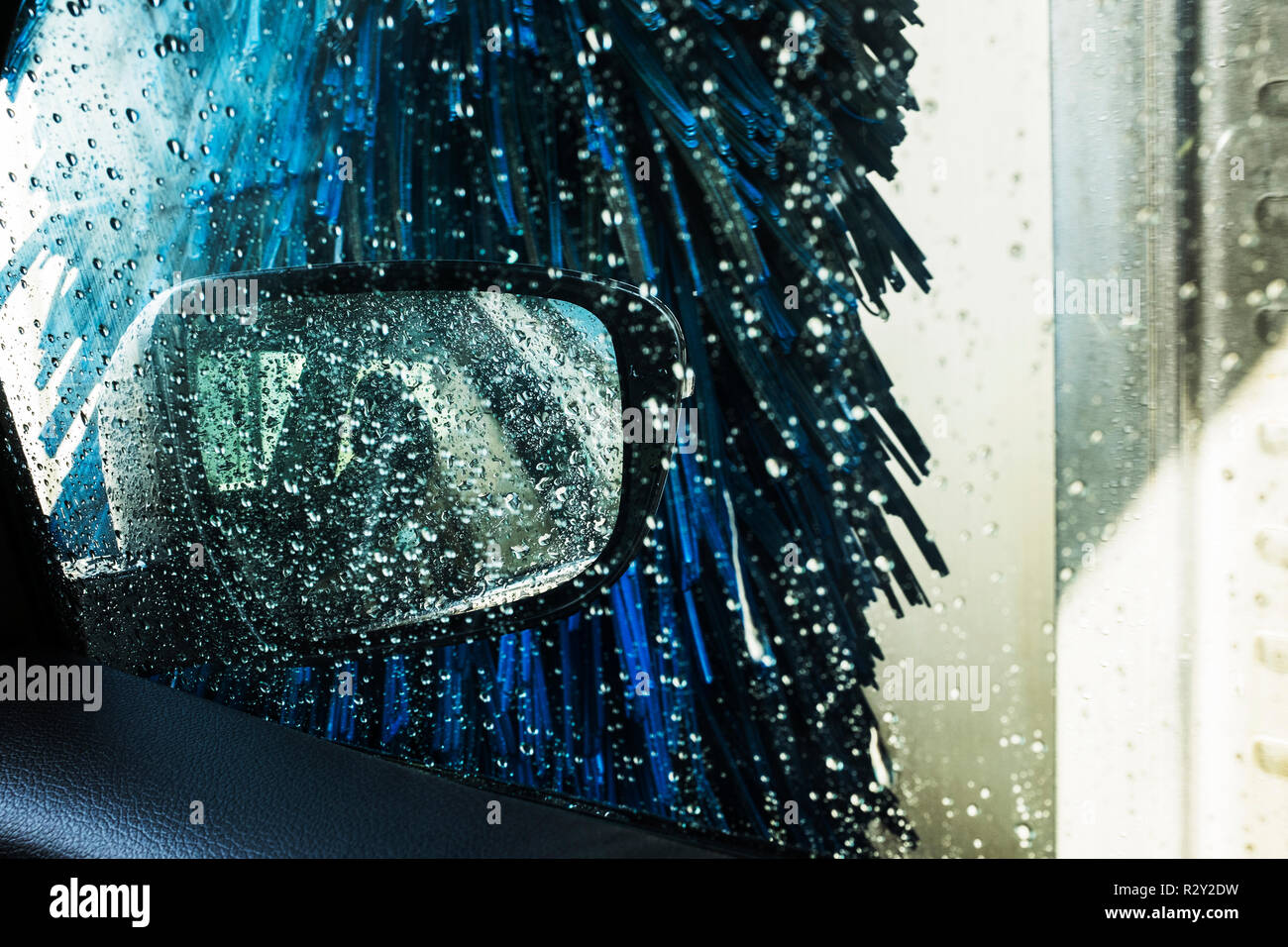 View from the inside of a car in an automated car wash, blue washers ...