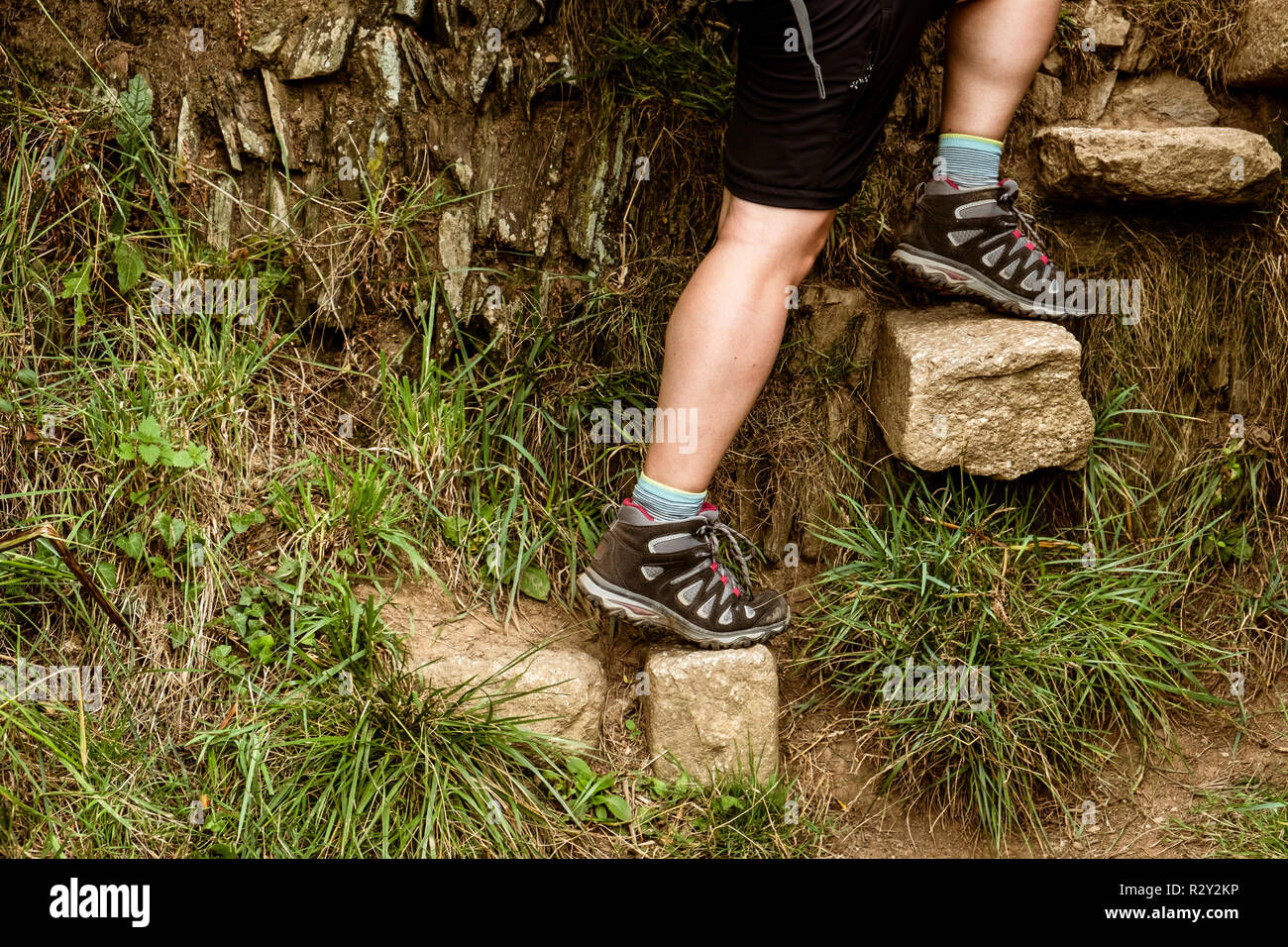 A man climbing up a set of stones set into a wall creating steps on a ...