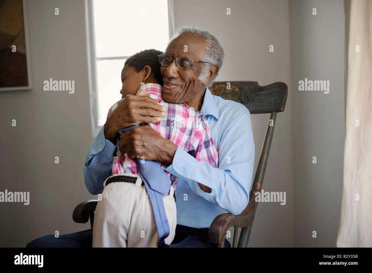 Grandfather hugging grandson Stock Photo - Alamy