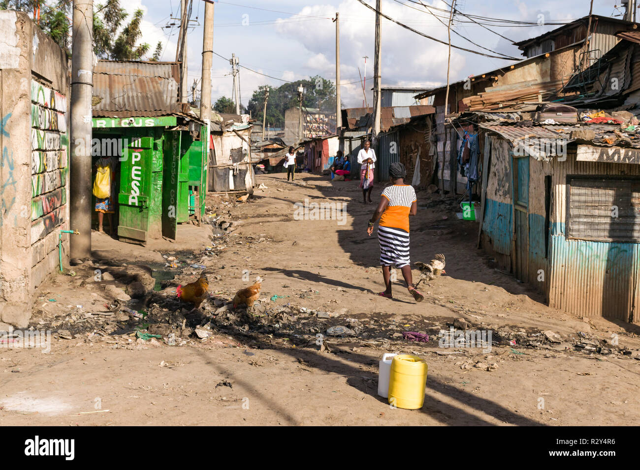 Typical view down a dirt road lined with corrugated metal shacks and ...