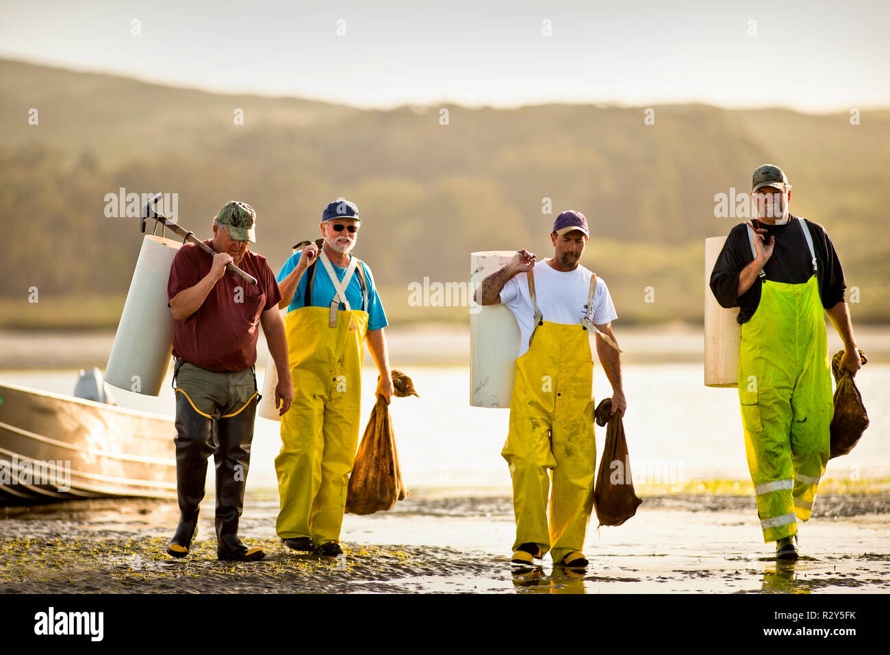 Group of fisherman on the beach with bags of shellfish Stock Photo - Alamy